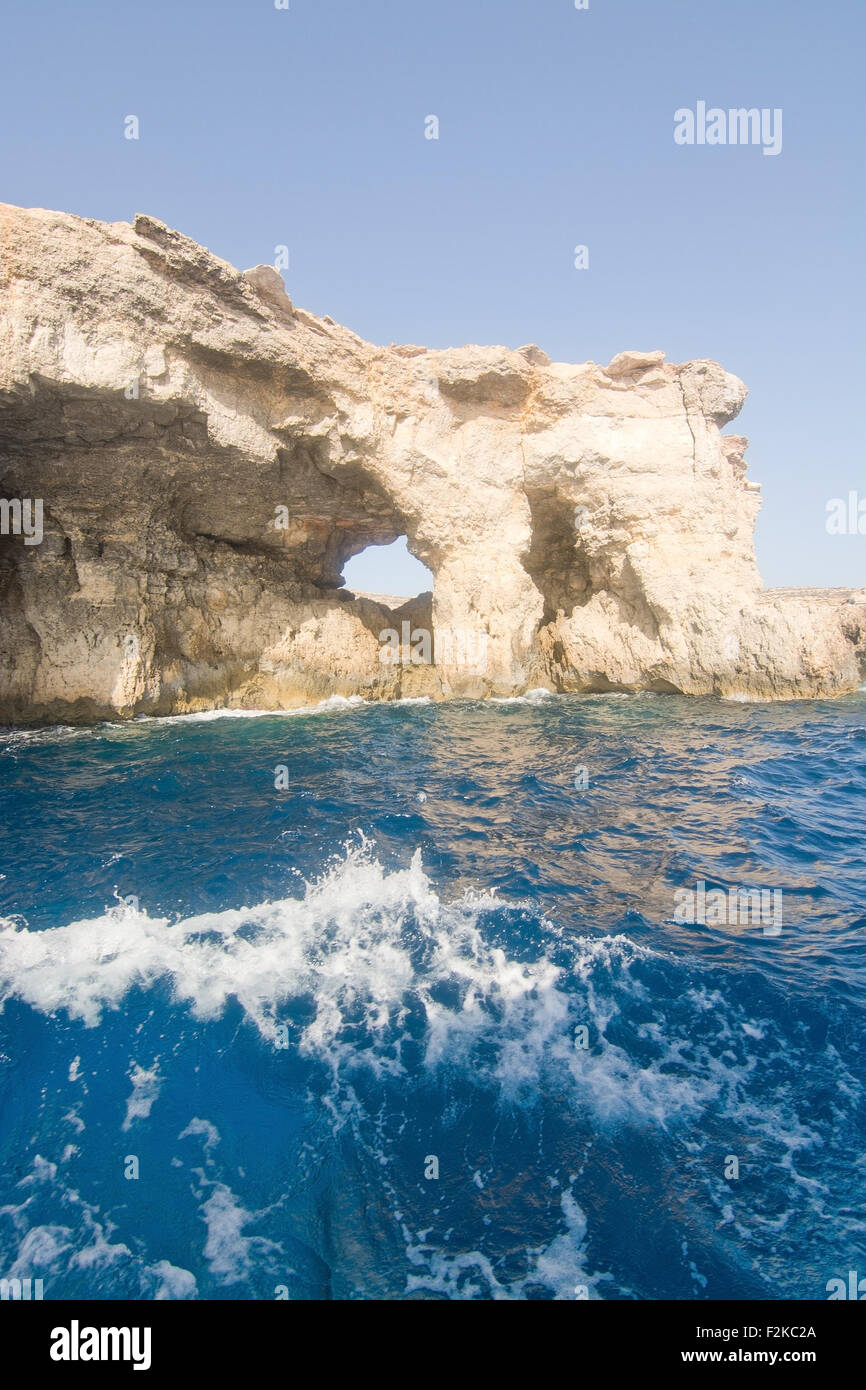 Limestone rock with caves and blue Mediterranean ocean water near ...