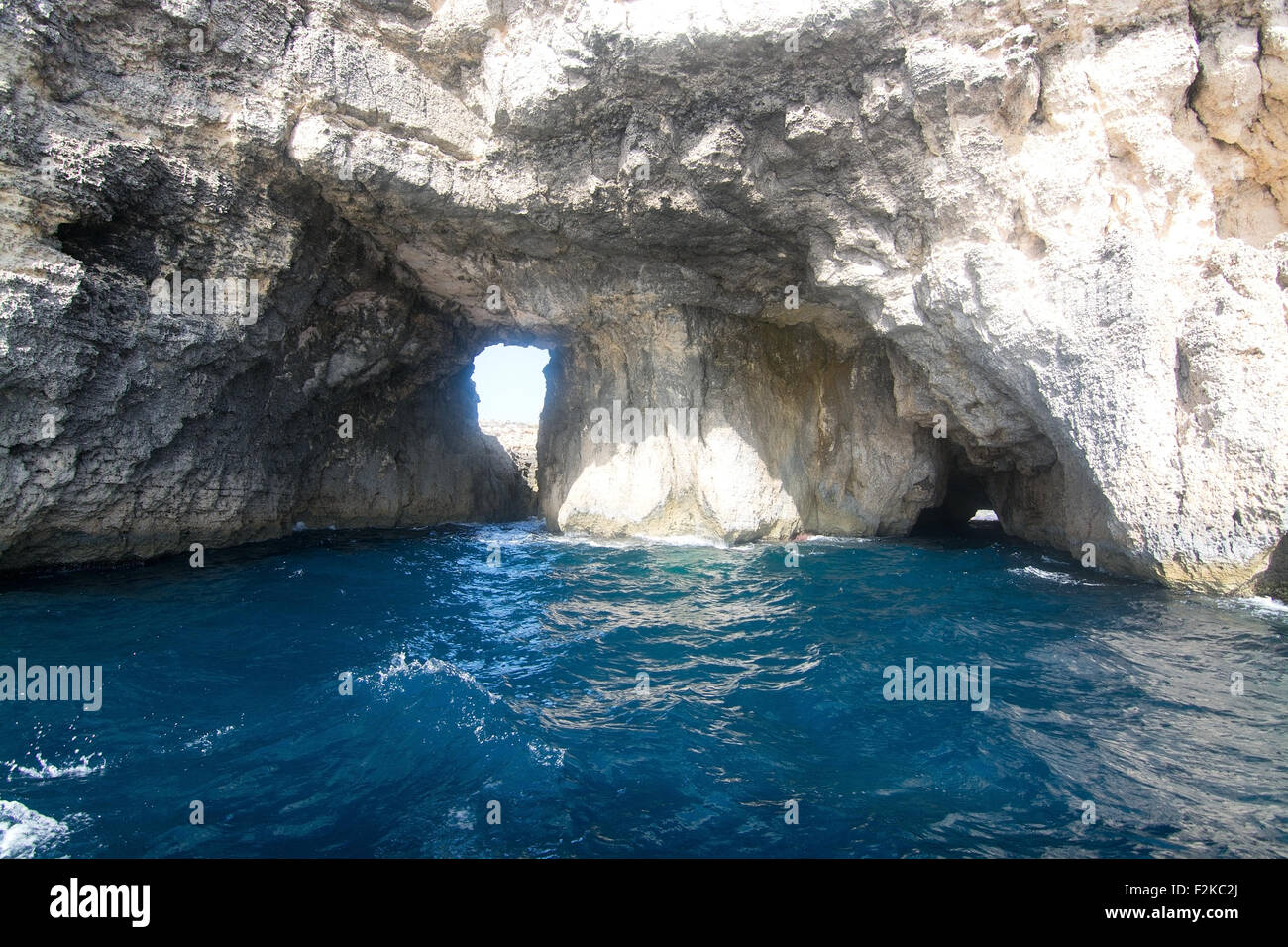 Limestone rock with caves and blue Mediterranean ocean water near ...