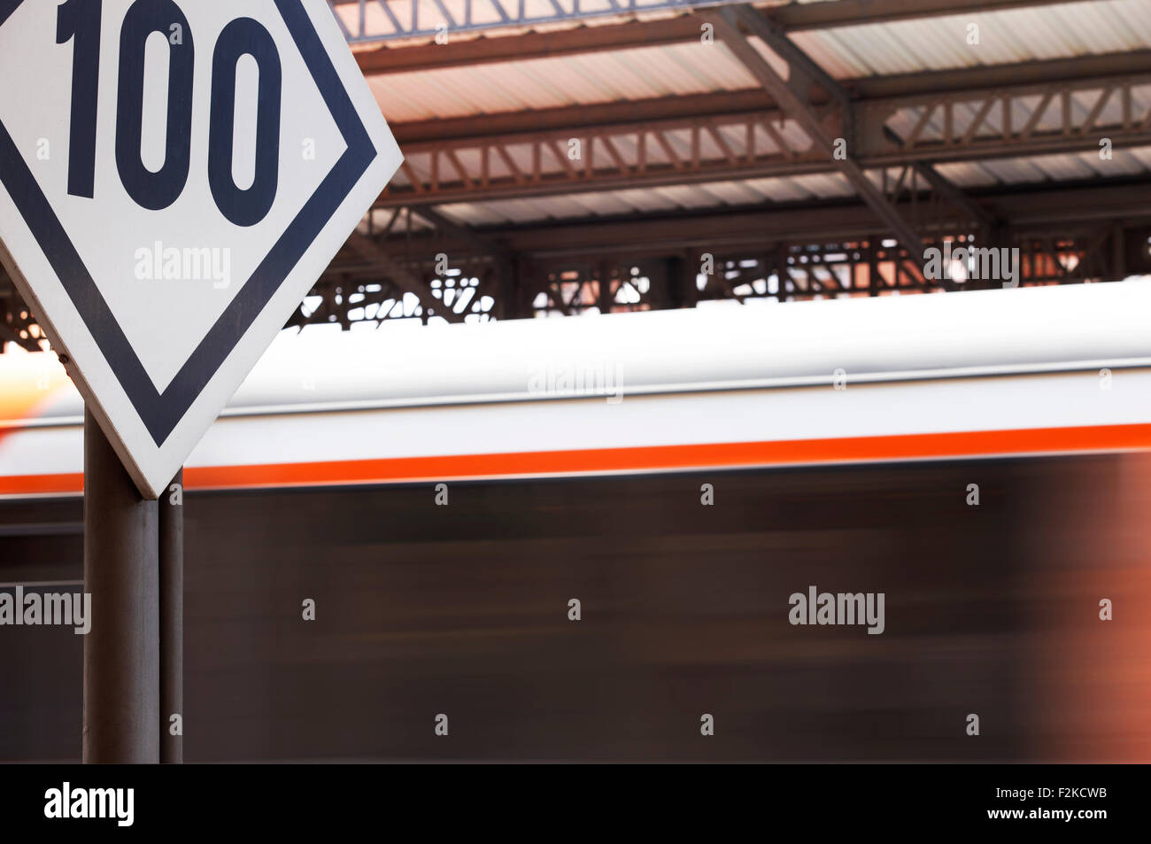Speed advice signpost at railway station with train in movement Stock ...