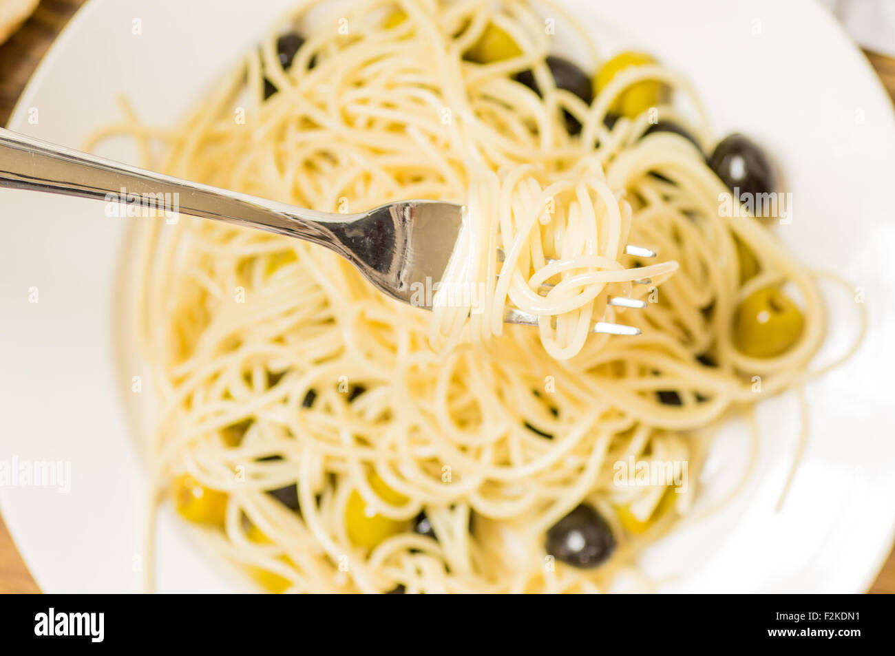 Fork with spaghetti pasta on a background of dishes with olives Stock ...
