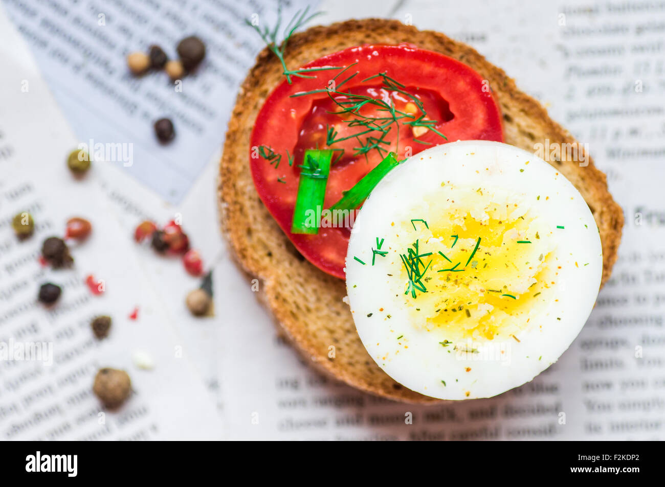 Sandwich with boiled egg and tomato on a newspaper Stock Photo - Alamy