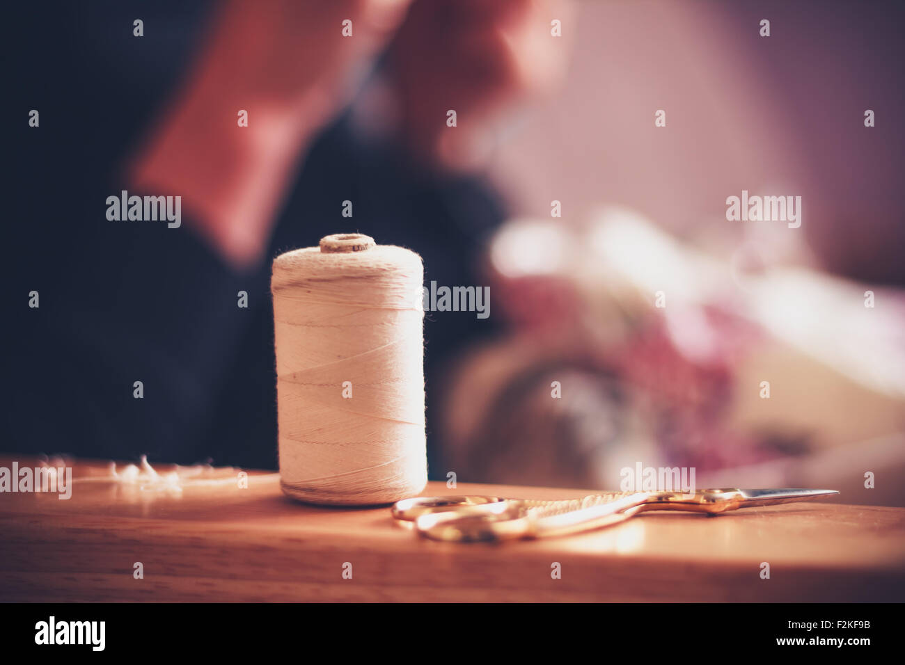 Needle and thread with small pair of scissors Stock Photo - Alamy