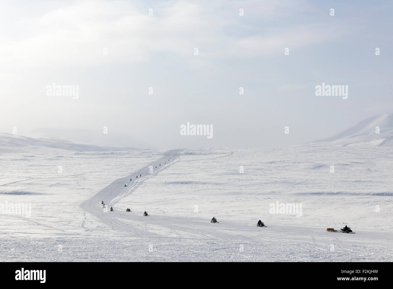 Group of snowmobiling people on the way at Arctic Spitsbergen ...