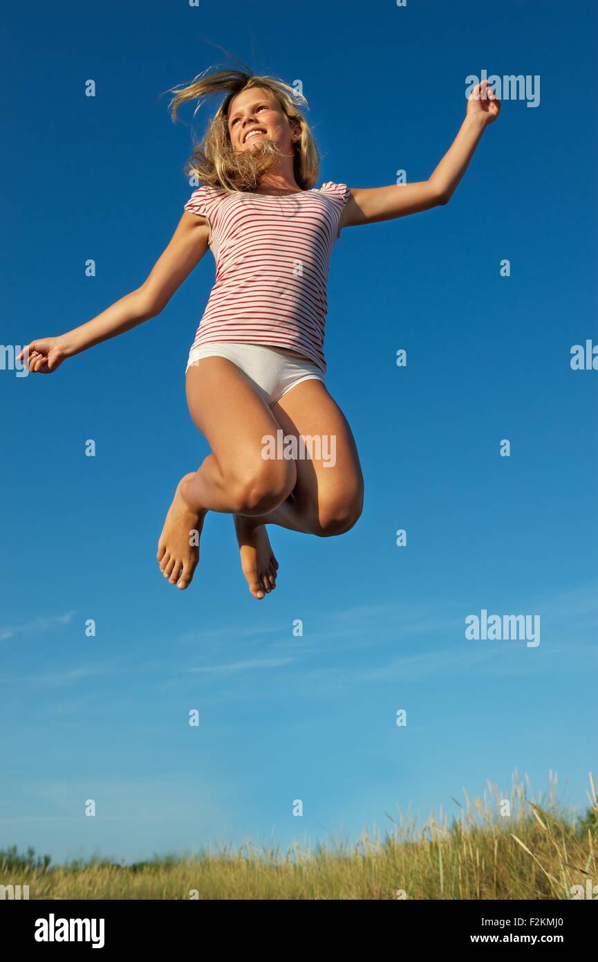 Happy little girl jumping Stock Photo - Alamy
