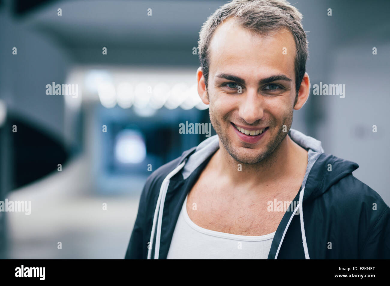 Portrait of smiling man wearing black hooded jacket Stock Photo - Alamy