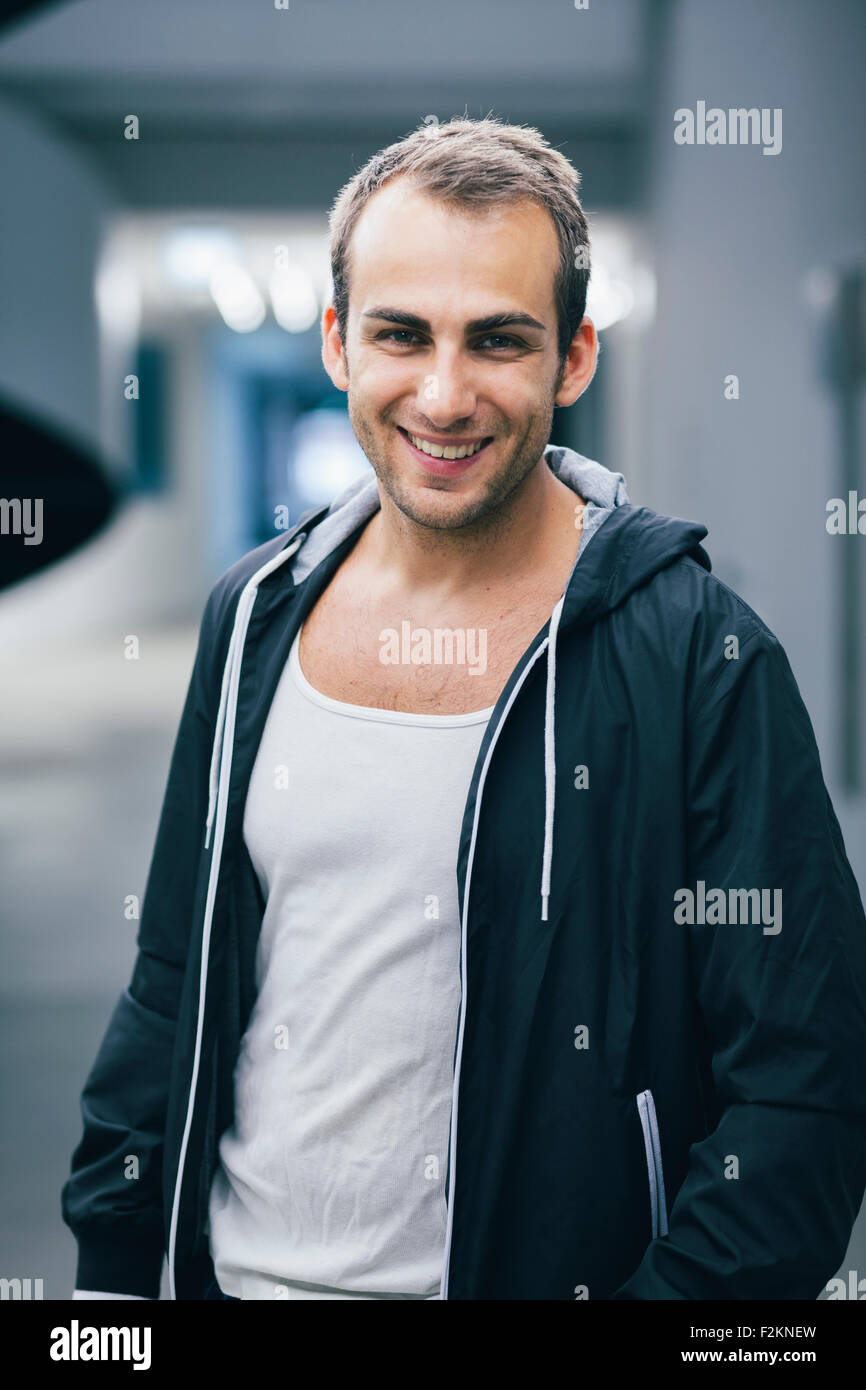 Portrait of smiling man wearing black hooded jacket Stock Photo - Alamy