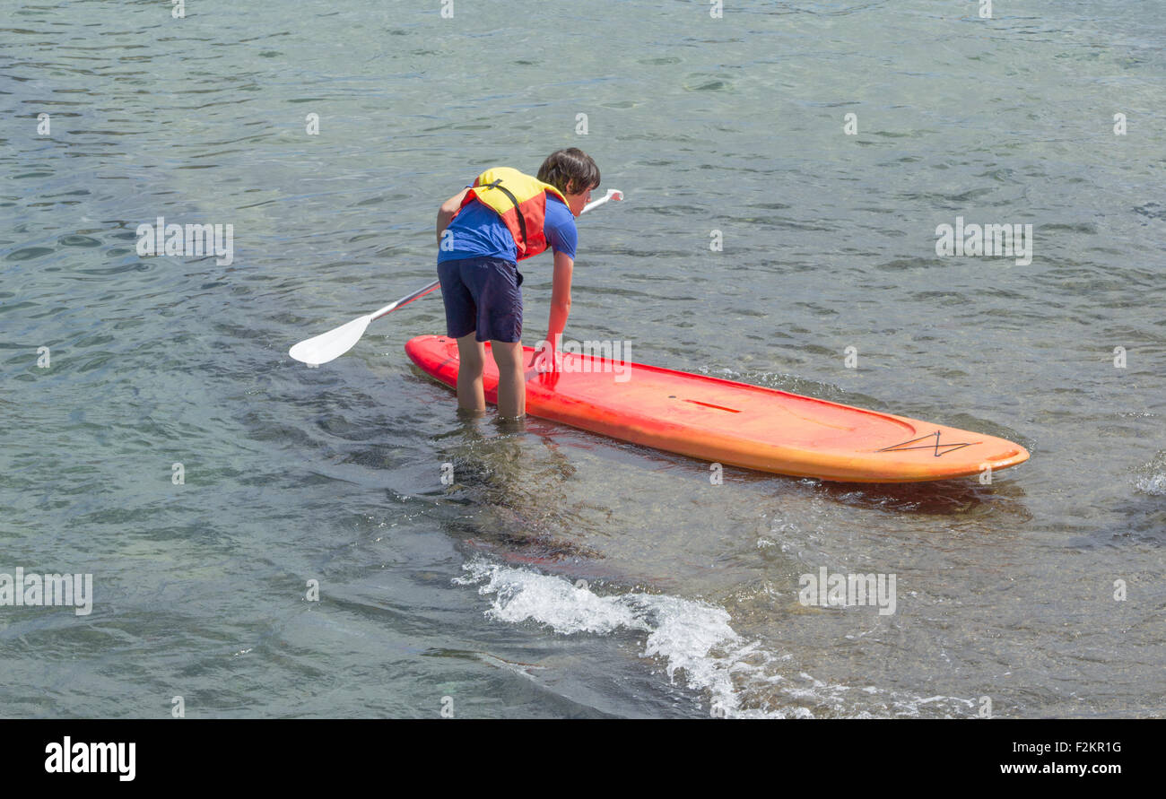 learning stand up and paddle - teenager launching a board Stock Photo ...