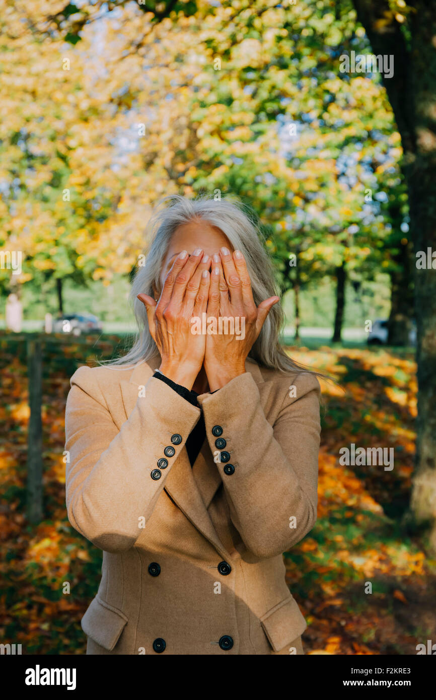 Woman hiding hands on grey hi-res stock photography and images - Alamy