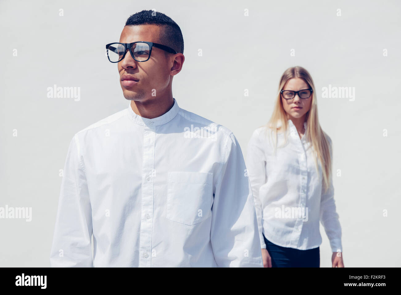 Portrait of stylish young couple wearing matching clothes in front of ...
