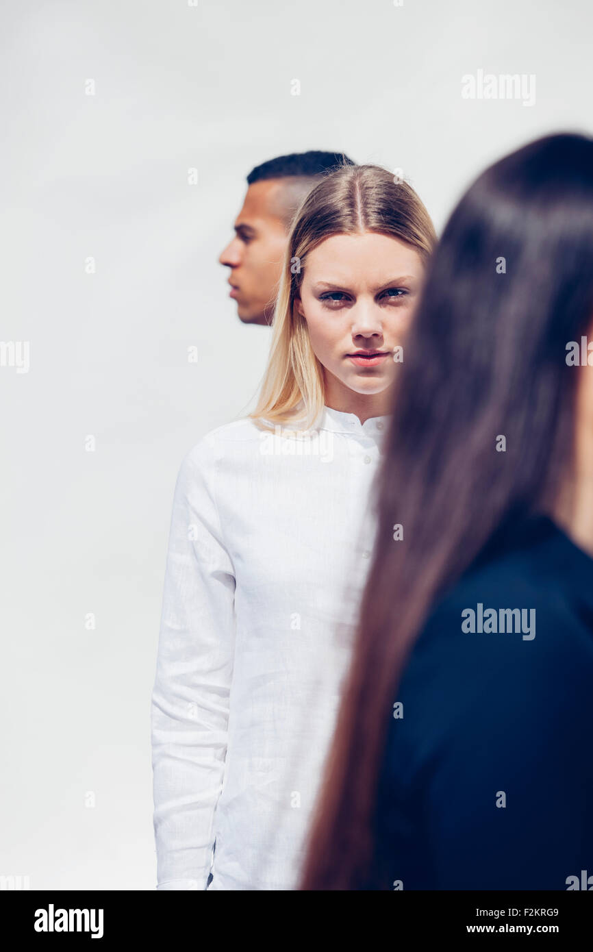 Portrait of young blond woman standing between two other people in ...