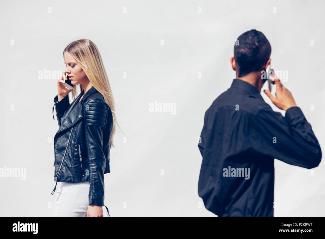 Two young people telephoning with smartphones Stock Photo - Alamy