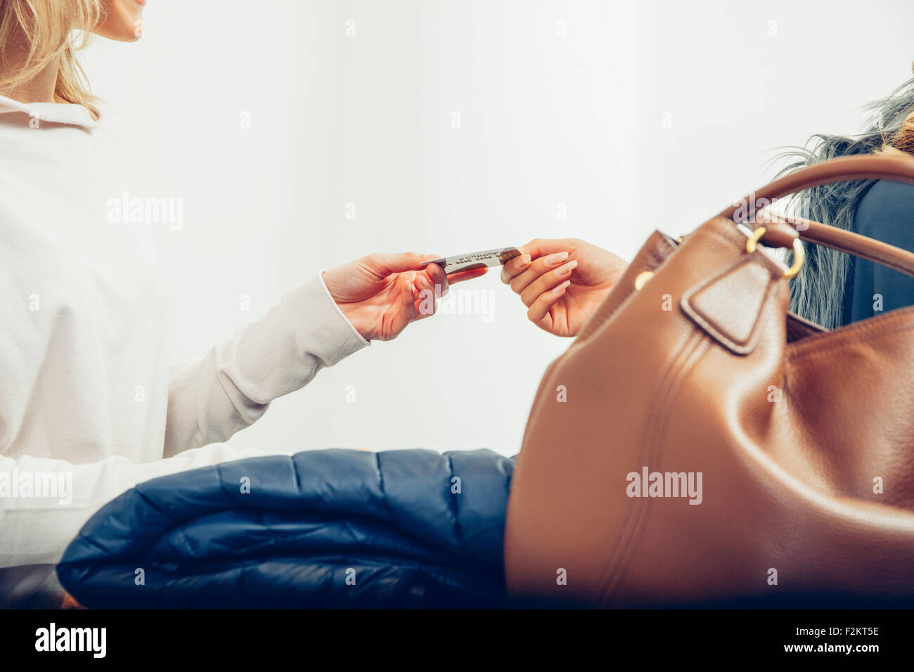 Woman paying at store counter in a boutique Stock Photo - Alamy
