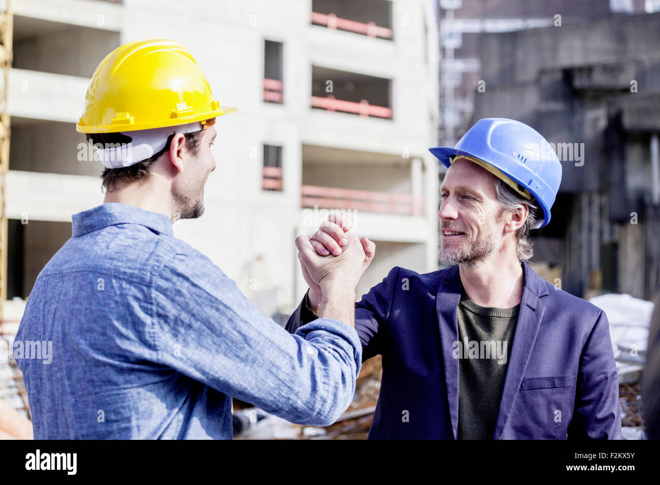 Two men on construction site shaking hands Stock Photo - Alamy
