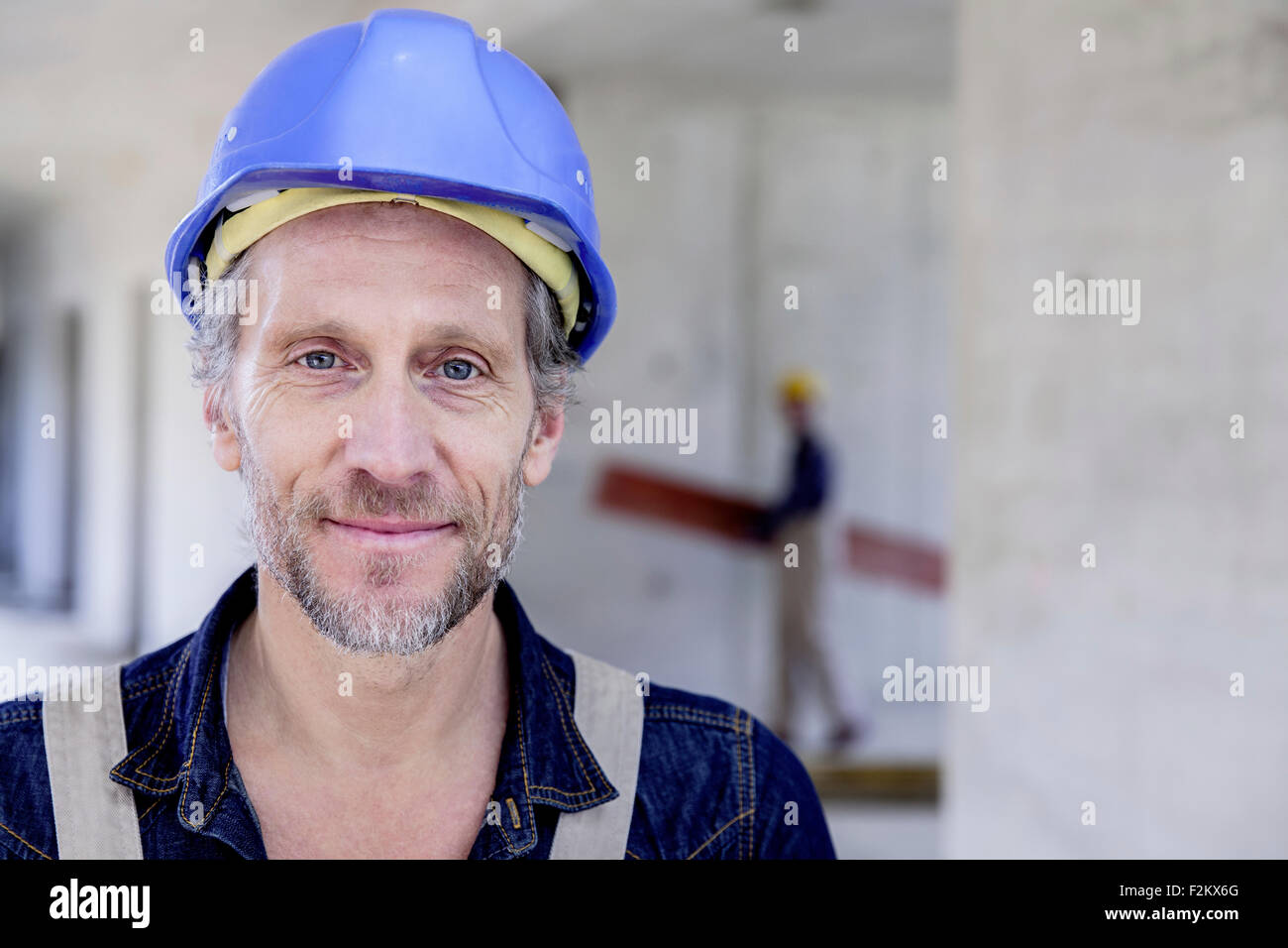 Smiling worker on construction site Stock Photo - Alamy