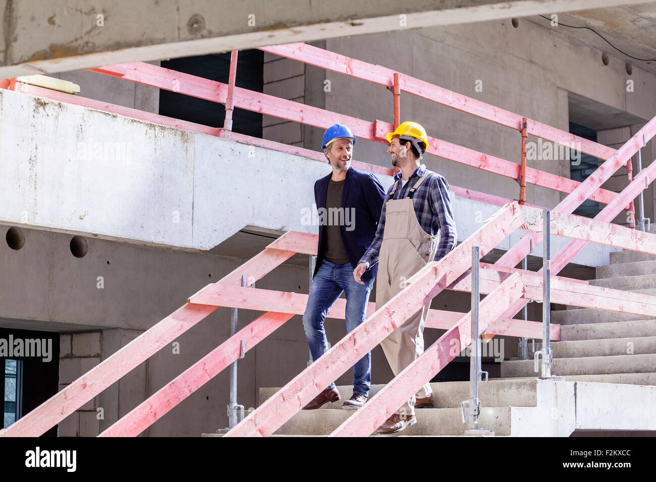Construction worker and architect on construction site walking ...