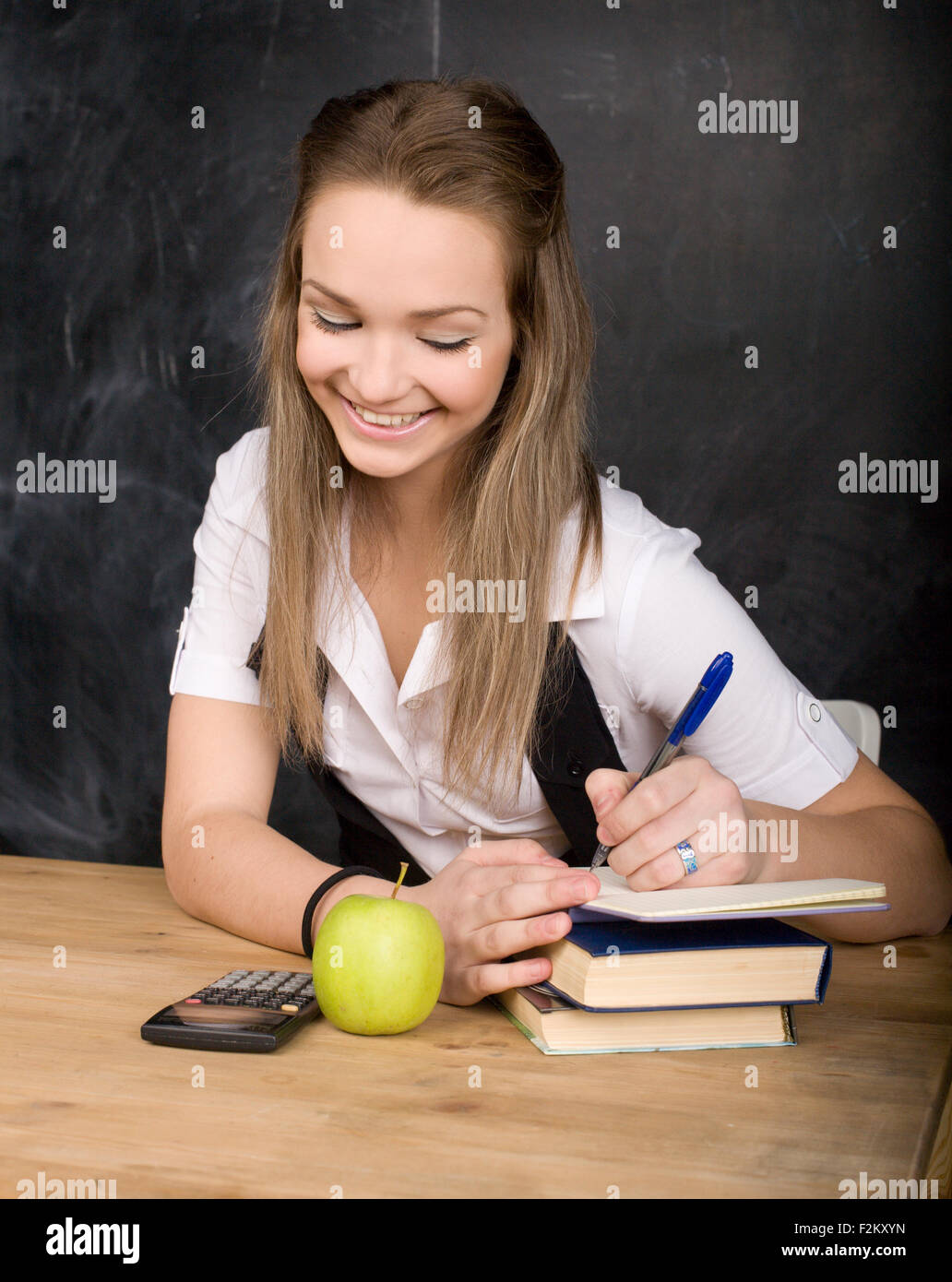 young pretty girl student in classroom at blackboard doing homework ...