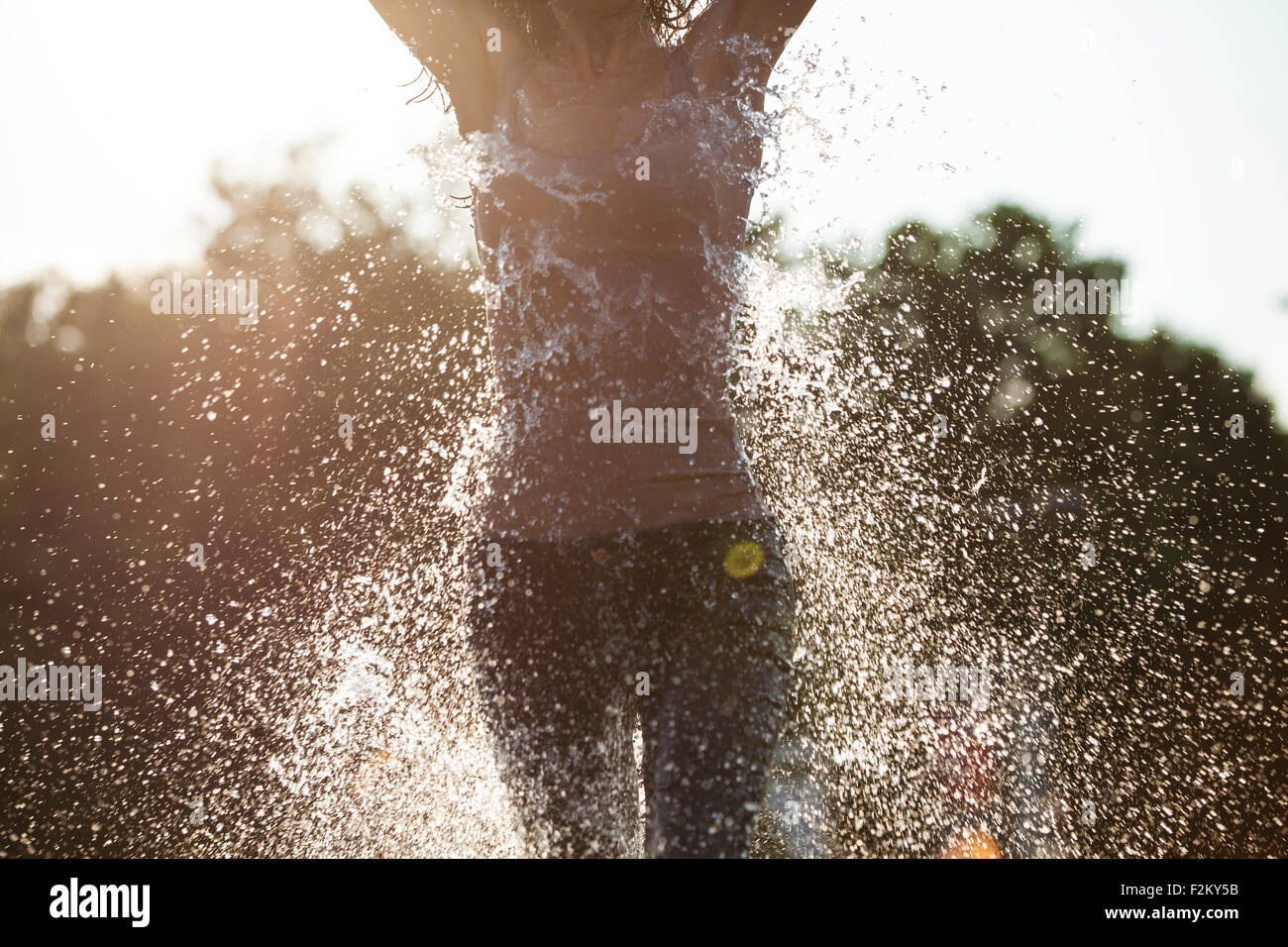 Woman running through fountain splashing water drops Stock Photo - Alamy