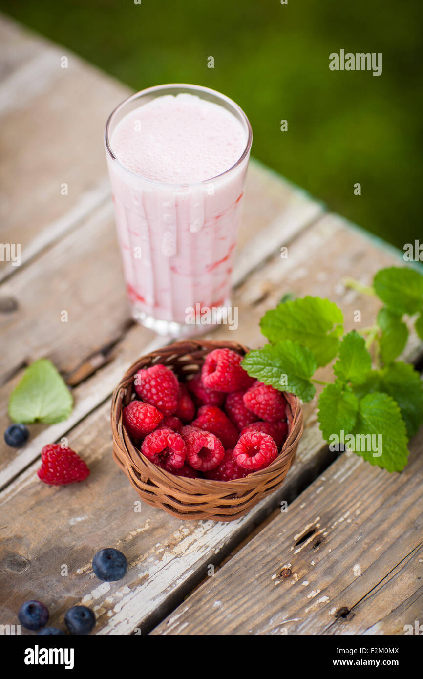 Fresh raspberry milkshake in glass, raspberries in basket Stock Photo ...