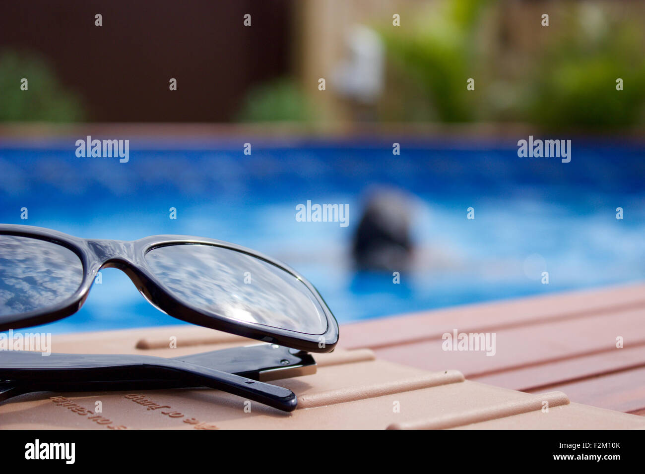 Sunglasses by the pool Stock Photo - Alamy
