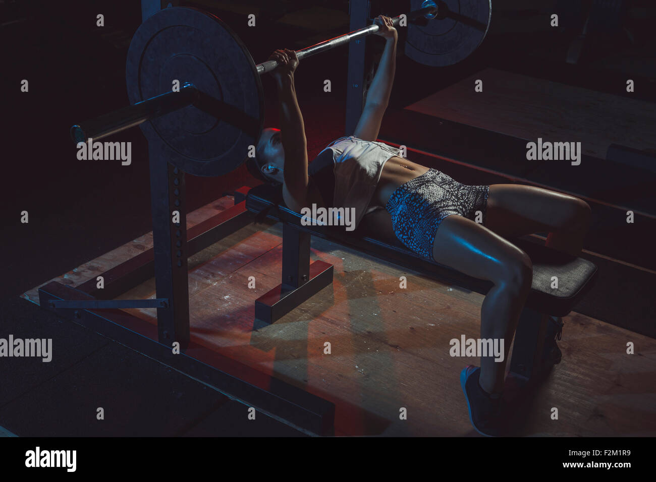 Female athlete doing bench presses with barbell Stock Photo - Alamy