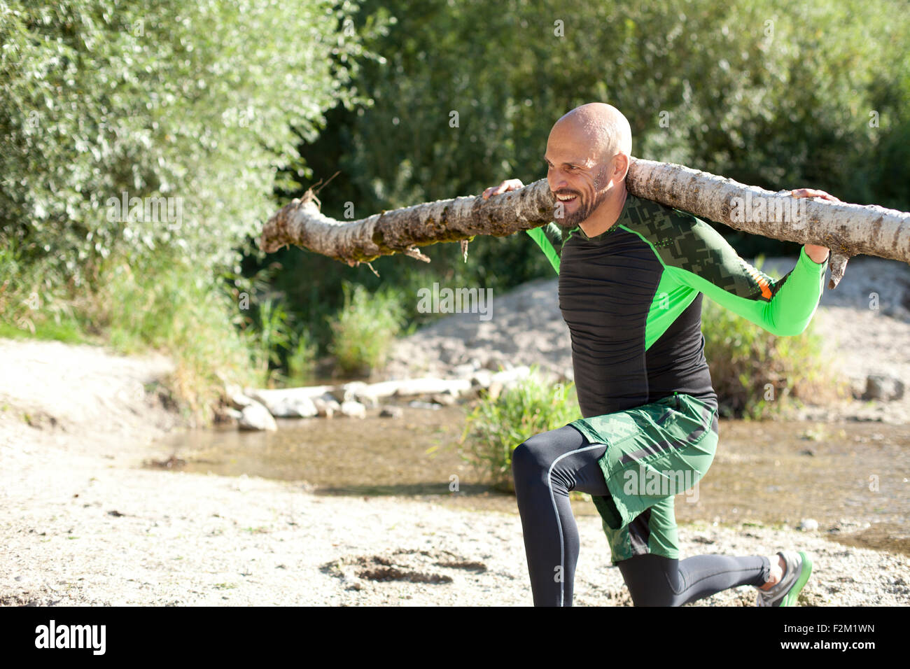 Man doing CrossFit exercise with tree trunk on his shoulders Stock ...