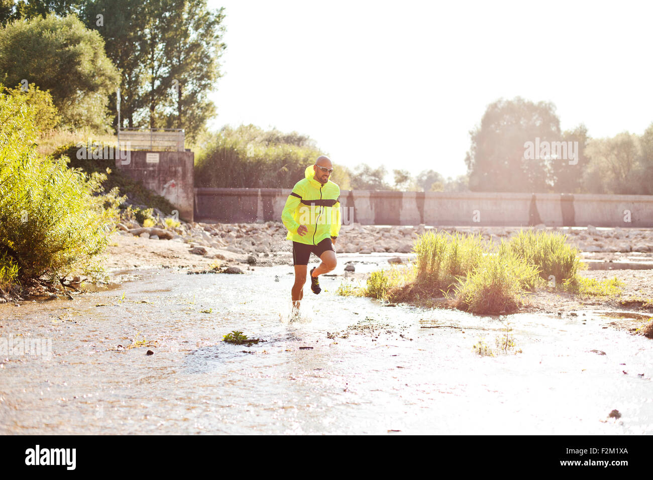 Man in sports wear running in water Stock Photo - Alamy