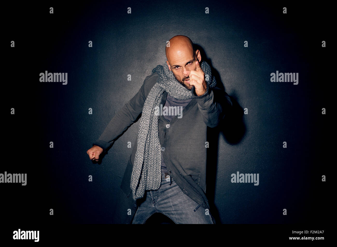 Portrait of angry man in front of black background Stock Photo - Alamy