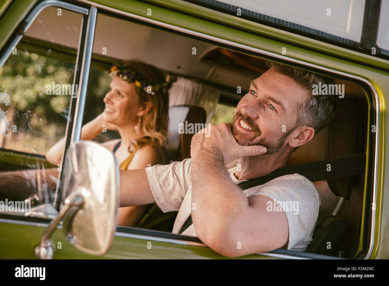 Smiling couple in van on a road trip Stock Photo - Alamy