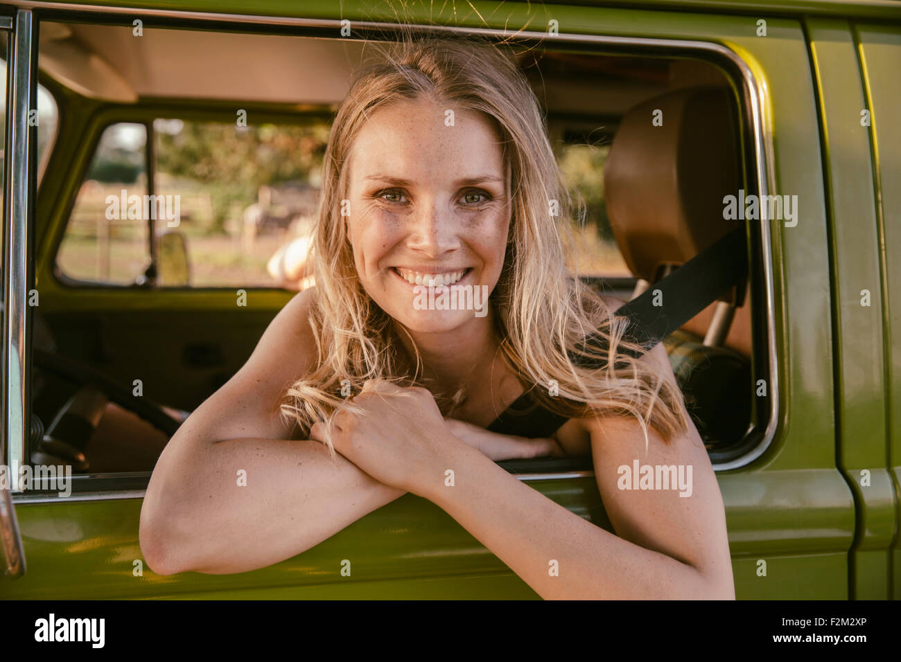 Smiling woman looking out of window in van Stock Photo - Alamy