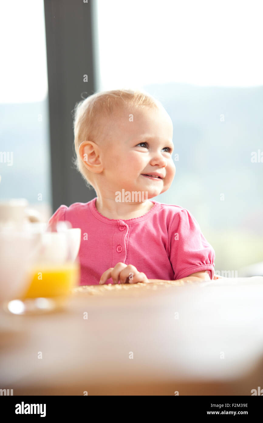 Smiling baby at beakfast table Stock Photo - Alamy