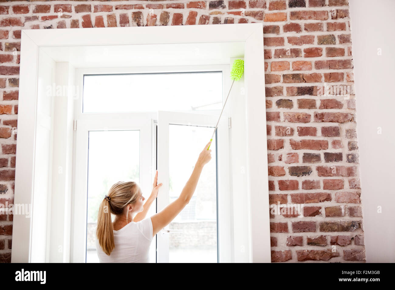 Woman dusting window Stock Photo - Alamy