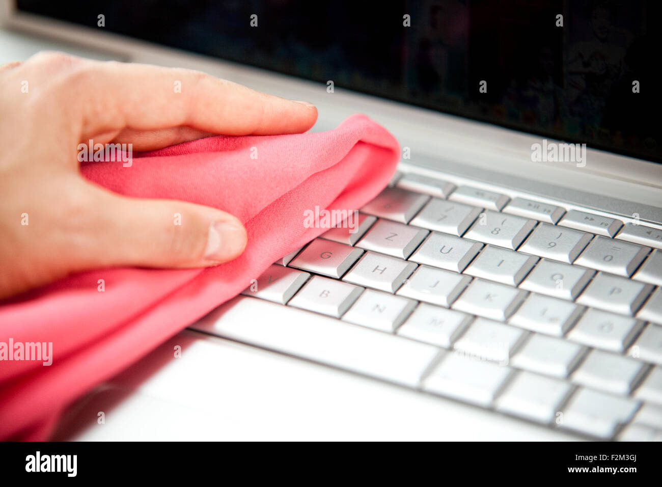 Woman cleansing laptop with duster Stock Photo - Alamy