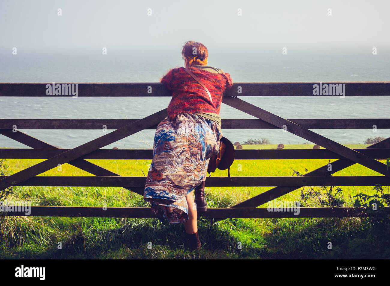 Woman leaning on fence hi-res stock photography and images - Alamy