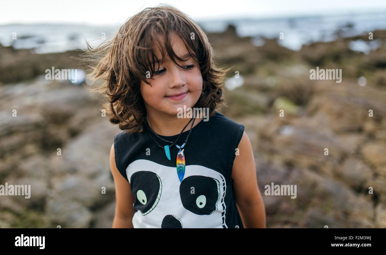 Spain, Gijon, portrait of smiling little boy at rocky coast Stock Photo ...
