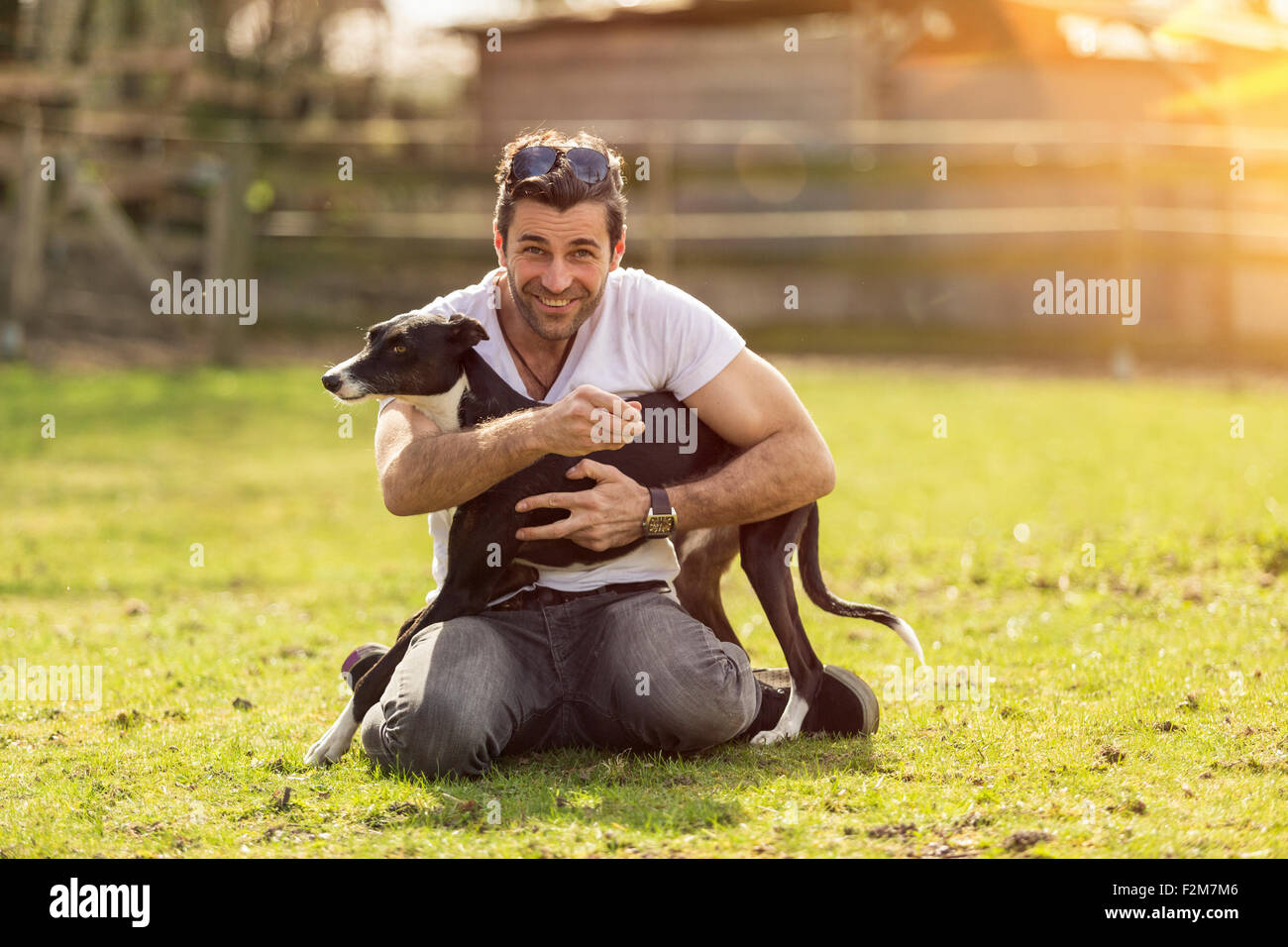 Portrait of man with his dog on a meadow Stock Photo - Alamy