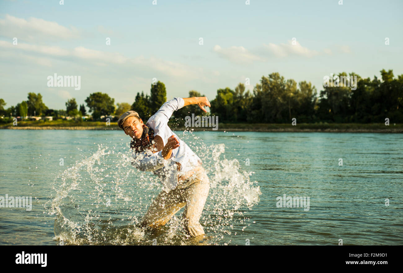 Man standing in the river splashing with water Stock Photo - Alamy