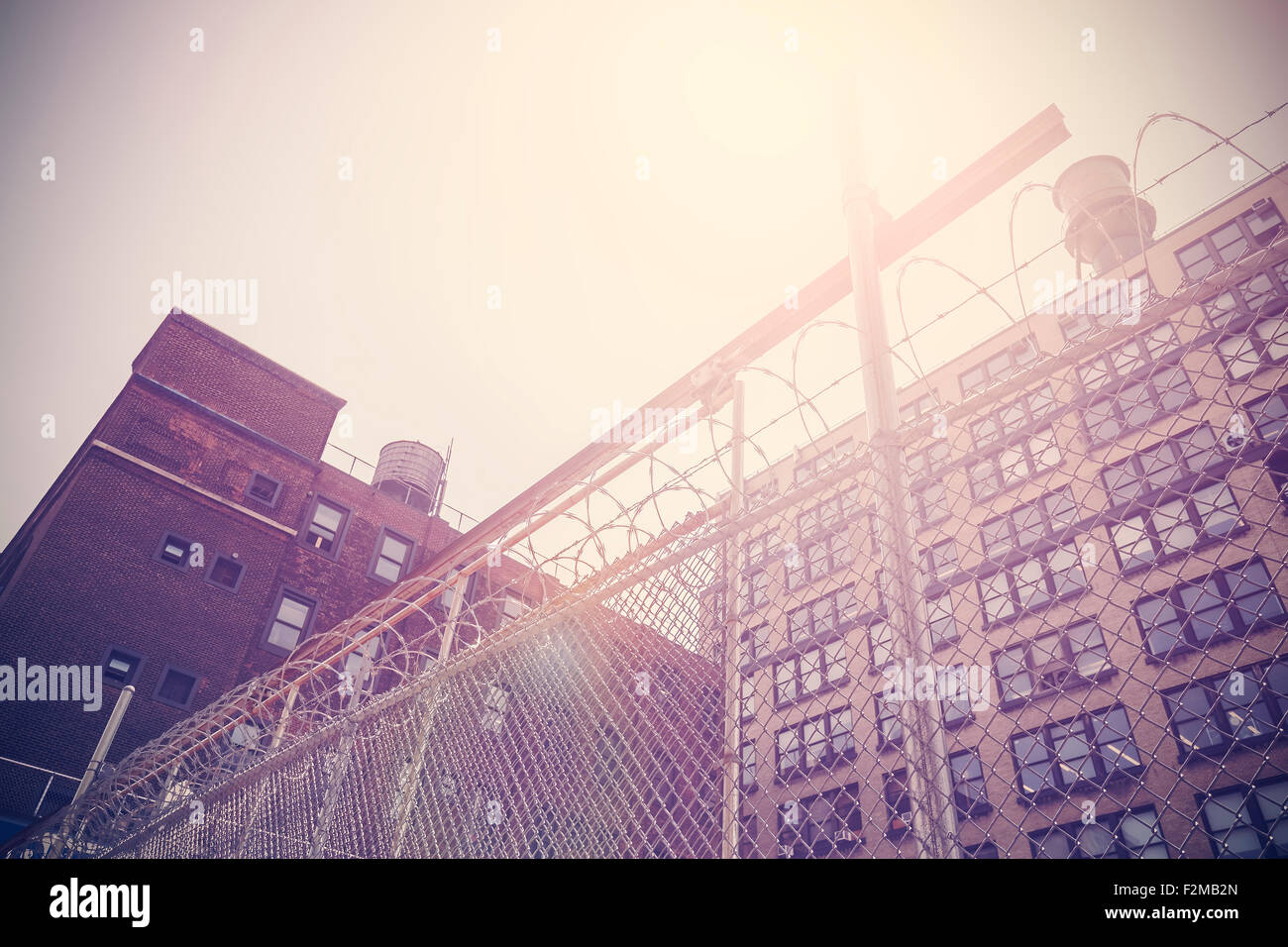 Retro toned old building protected with barbed wire fence, New York ...