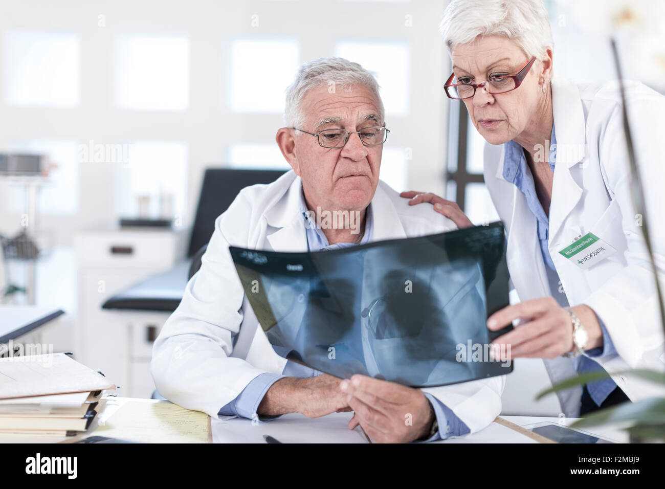 Two doctors at desk discussing x-ray Stock Photo - Alamy