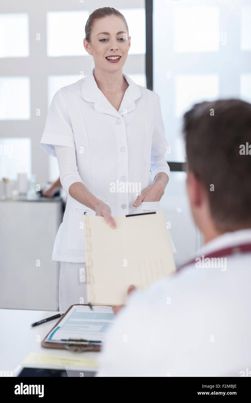 Doctor giving patient documents hi-res stock photography and images - Alamy