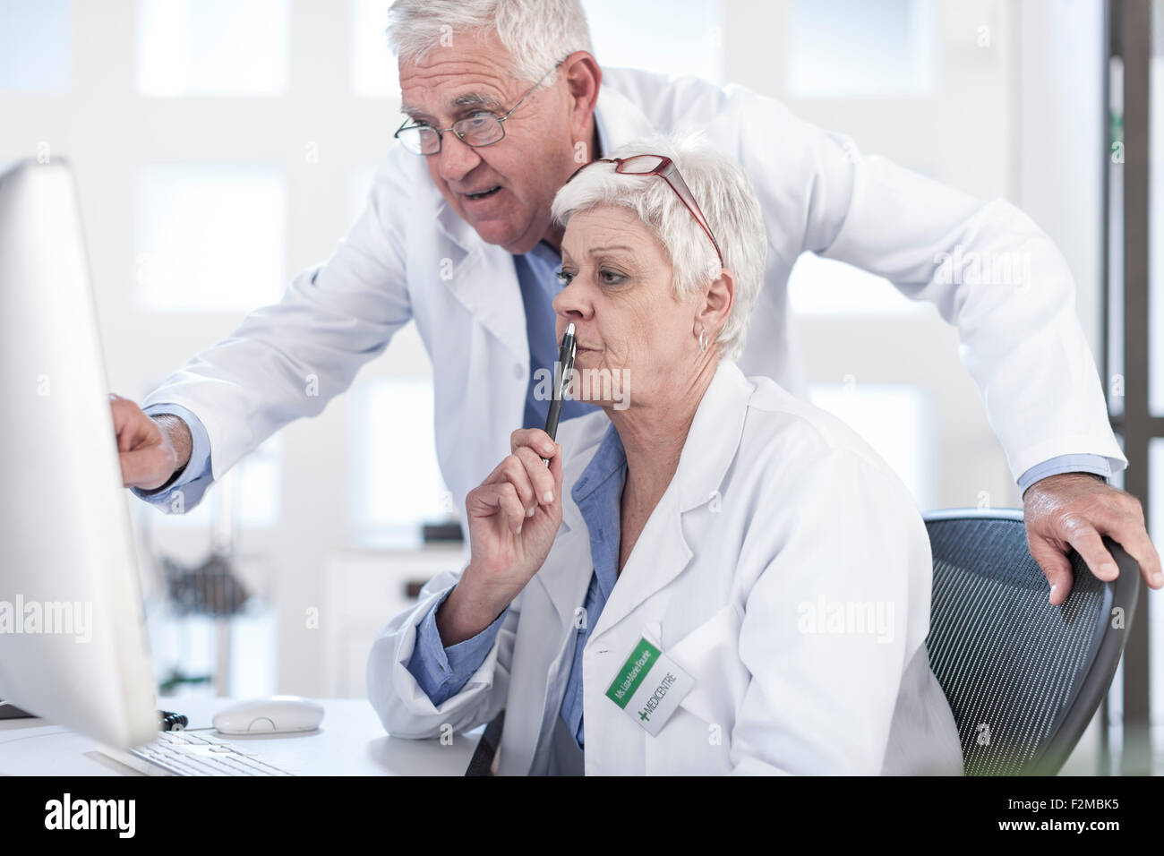Two doctors talking at desk Stock Photo - Alamy