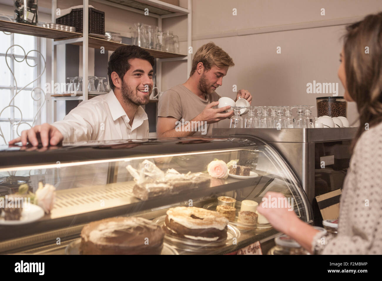 Young woman choosing cake from cake counter in coffee shop Stock Photo ...