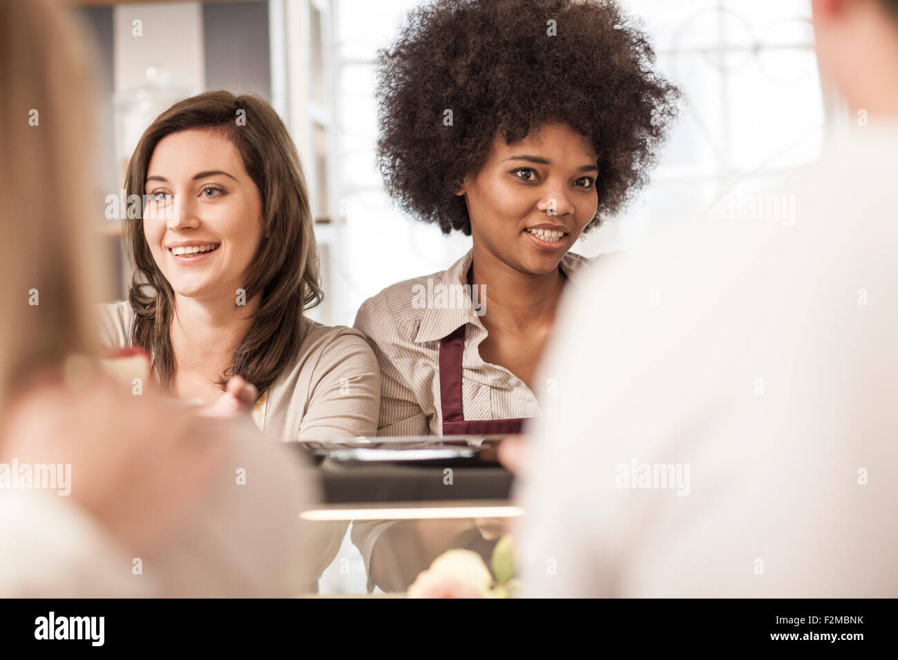 Young women serving cake at cake counter in coffee shop Stock Photo - Alamy