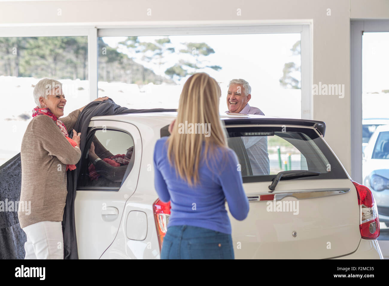 Father and mother unveiling new car as gift for the daughter Stock ...