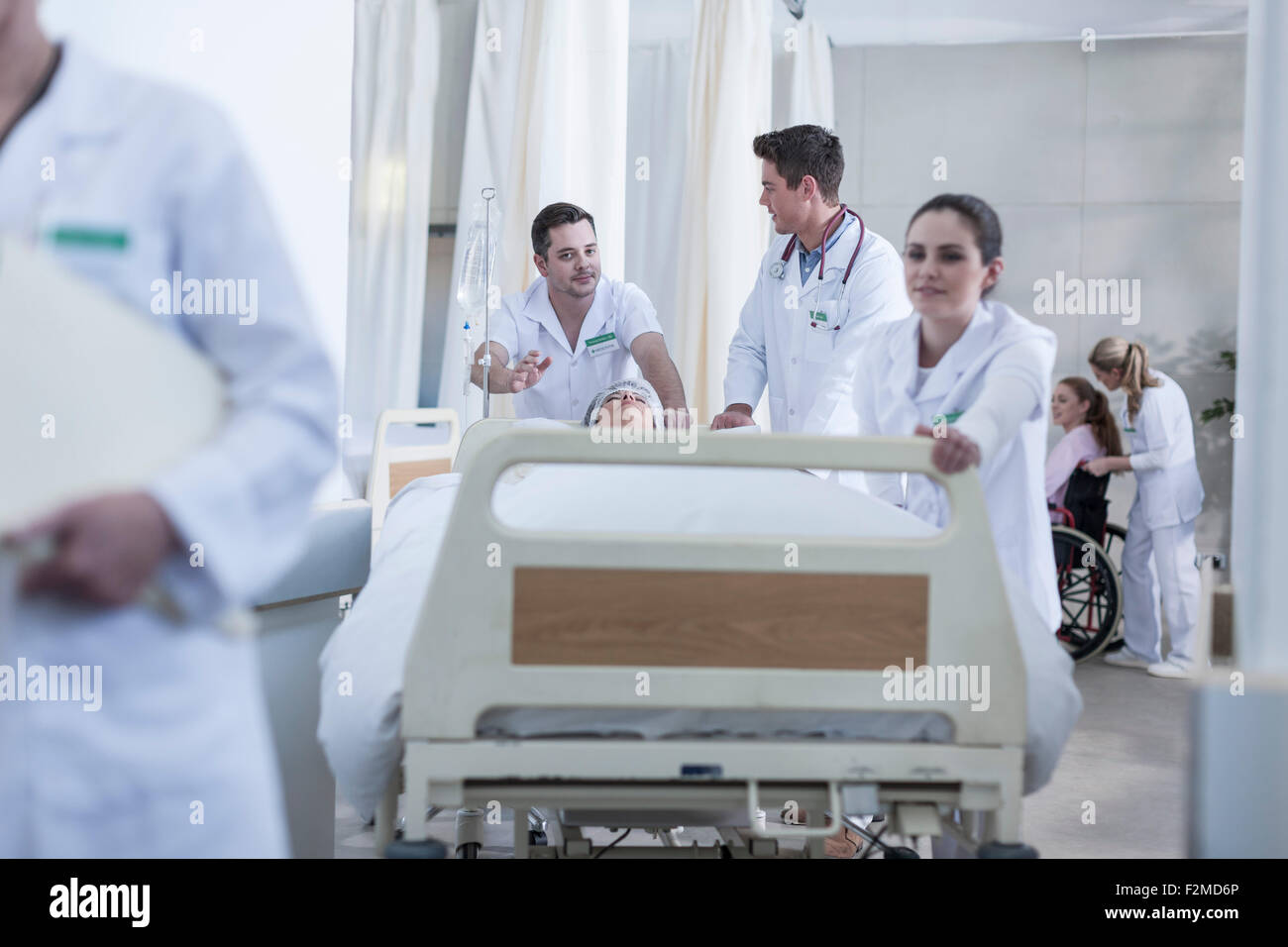 Hospital staff pushing bed with patient on floor Stock Photo - Alamy