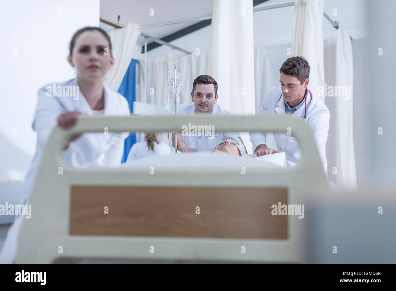 Hospital staff pushing bed with patient on floor Stock Photo - Alamy