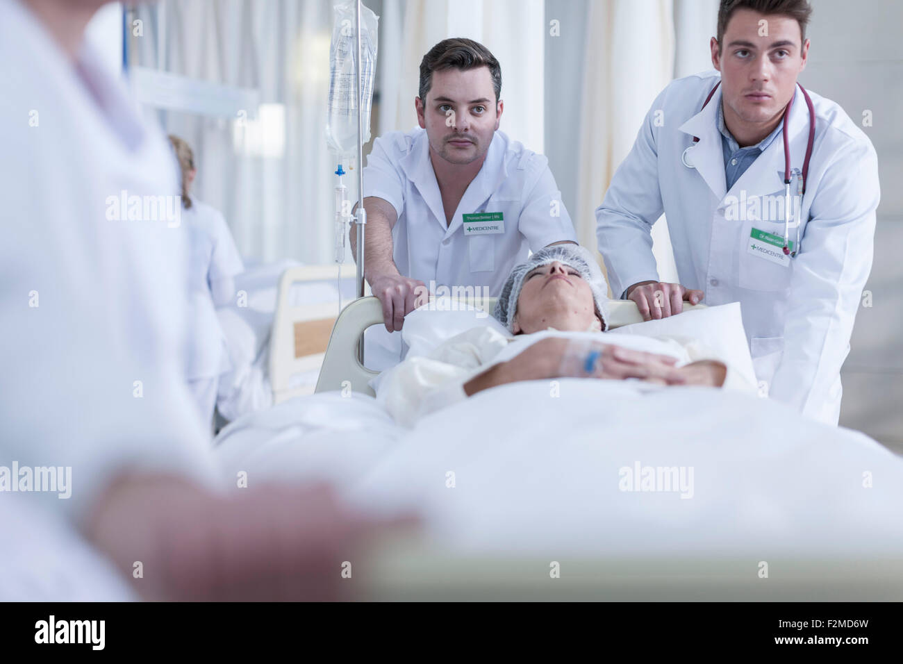Hospital staff pushing bed with patient on floor Stock Photo - Alamy