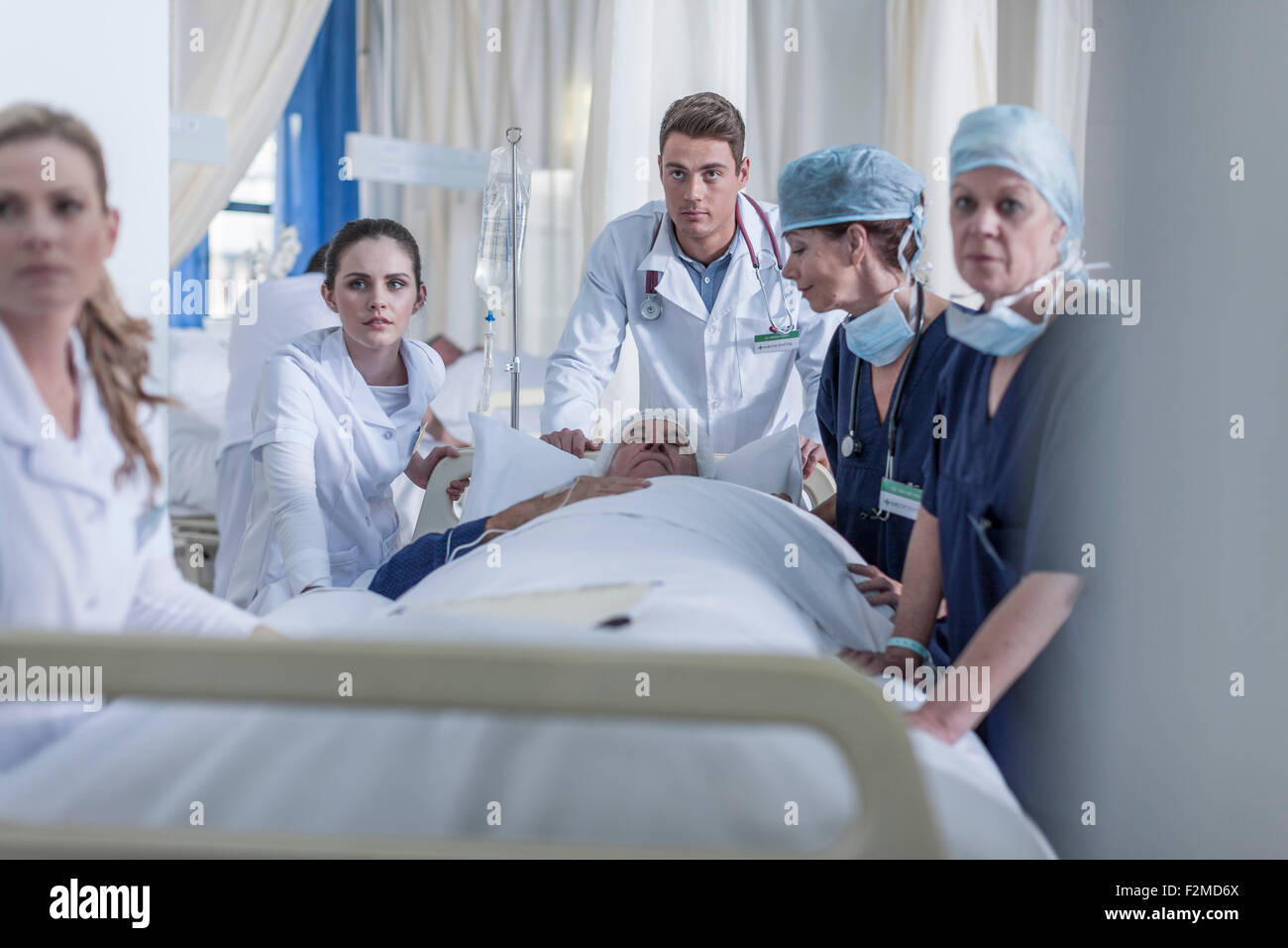 Hospital staff at bed with patient Stock Photo - Alamy