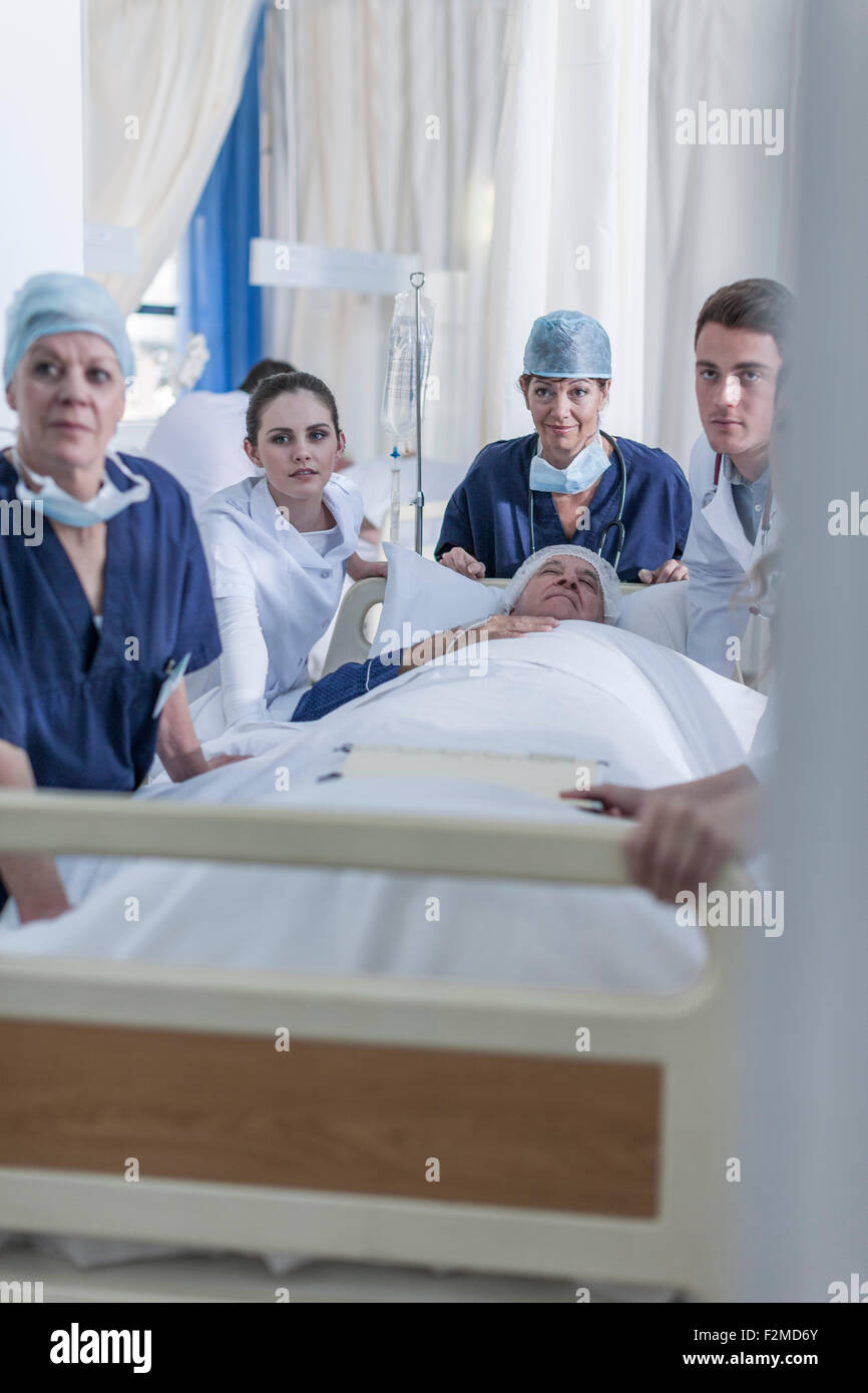 Hospital staff at bed with patient Stock Photo - Alamy