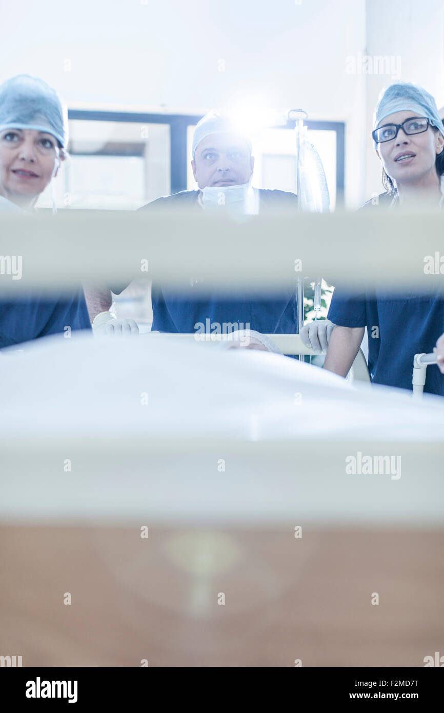 Surgeons at hospital bed with patient Stock Photo - Alamy