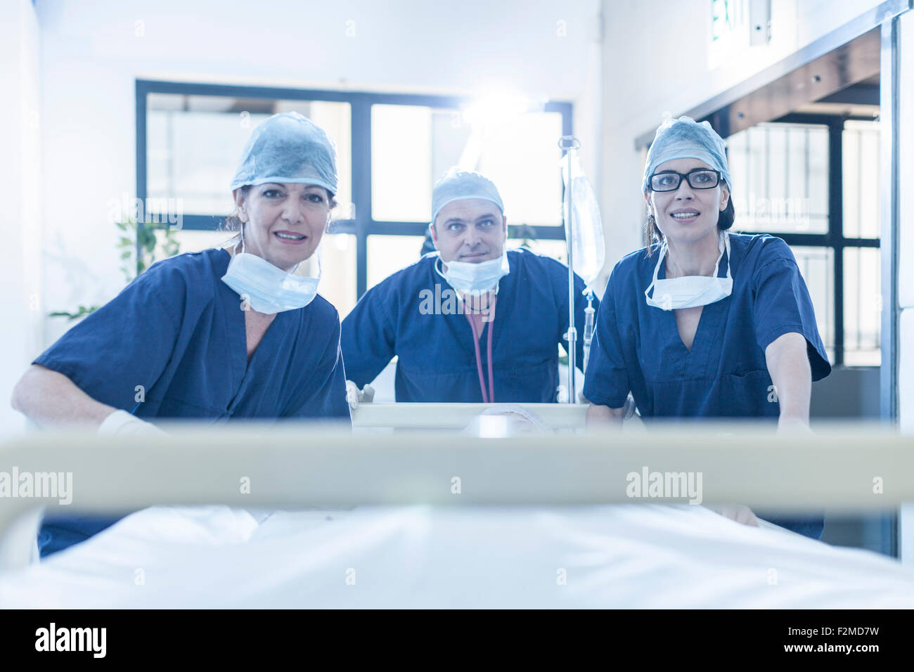 Surgeons at hospital bed with patient Stock Photo - Alamy